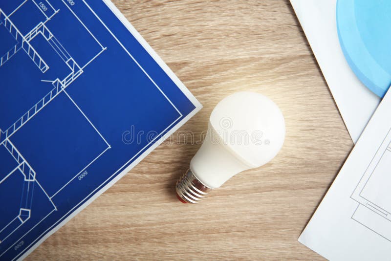 Lamp Bulb and Blueprint on Wooden Table Stock Photo - Image of design ...