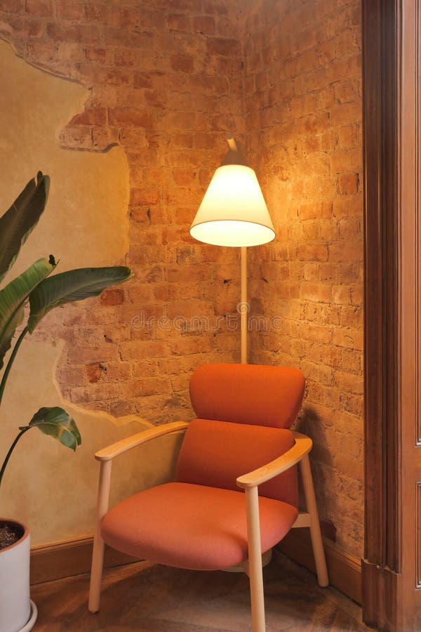 A Lamp and a Chair at Home Against Brick Wall Stock Photo - Image of ...