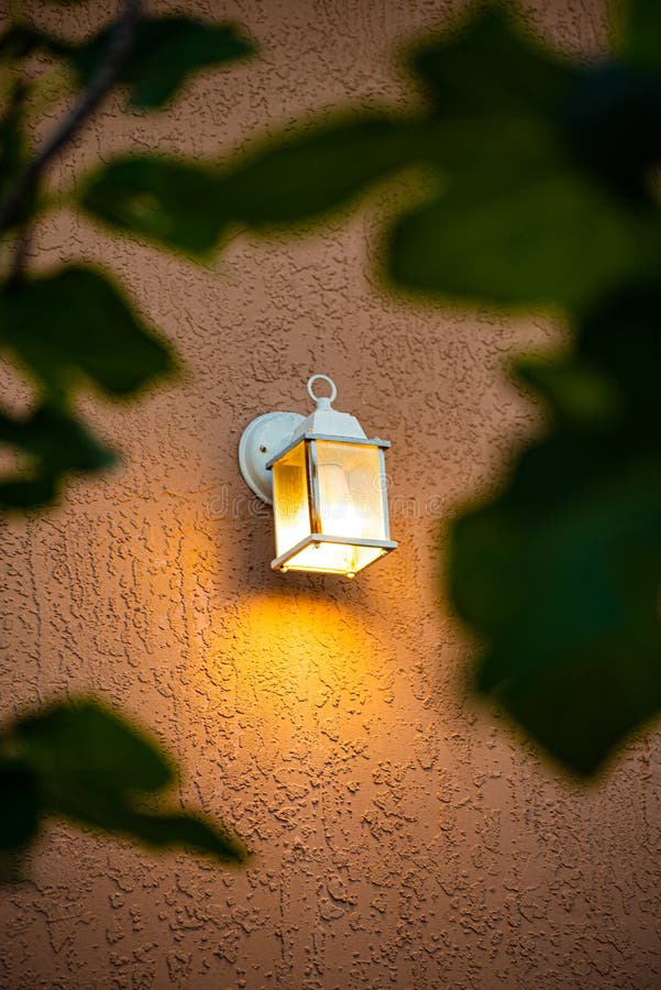 A Lamp Lit on the Wall of a House Stock Photo - Image of home ...