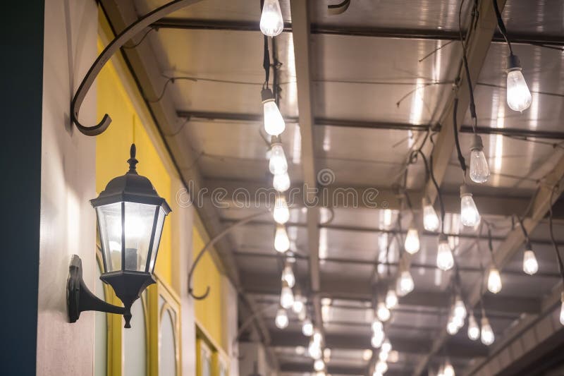 Lamp on Wall with Many Light Bulbs Hanging on Ceiling Stock Photo ...