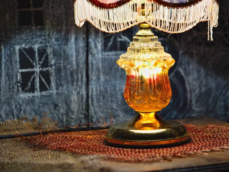 A Lamp with Yellow Light Stands on a Table. Black Wall Painted with ...