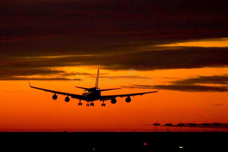 Plane Landing At Sunset