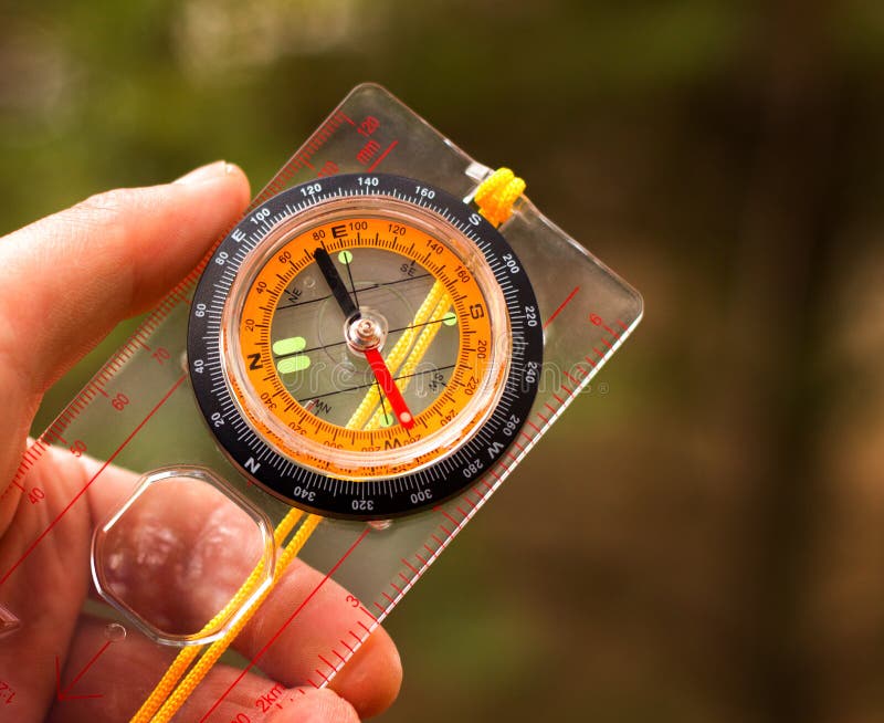 Compass in the Hand is Brightly Illuminated by the Sun on a Blurred ...