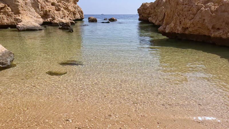 A Landscape Featuring a Rocky Beach with Water in the Foreground Under ...