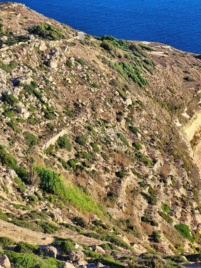 A Landscape of Rocks Covered in Greenery Under the Sunlight and a Blue ...