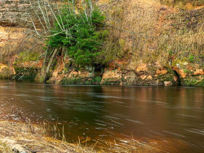 A Landscape with a Steep River and Caves on a Sandstone Cliff Stock ...