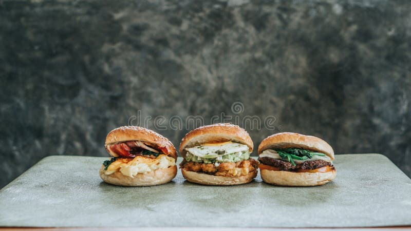 Landscape of Three Burgers on a Plate, Each with Different Toppings and ...