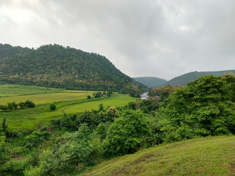 Landscape View of a Valley, Green Fields with Mountains and Dark Clouds ...