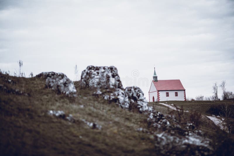 Landscape of a White and Red Building Surrounded by Stones and Greenery ...