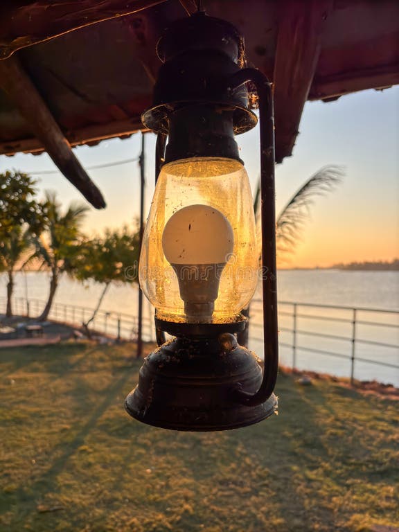 A Lantern with a Light Bulb Inside is Hanging from a Pole Stock Photo ...
