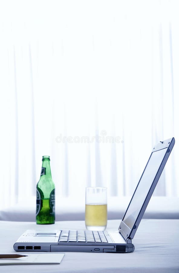Laptop and beer on the bed stock photo. Image of side - 195240434