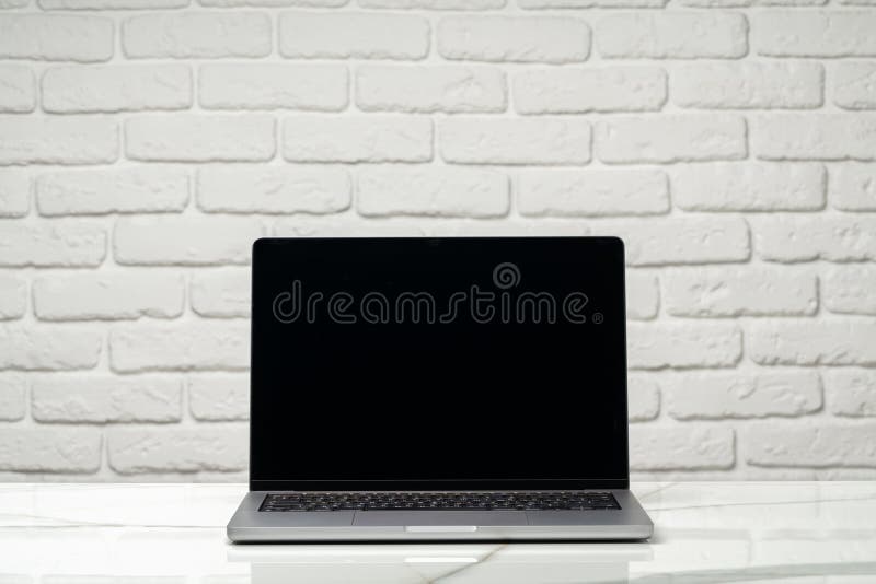 Laptop with Black Screen on Desk Against White Brick Wall Stock Image ...