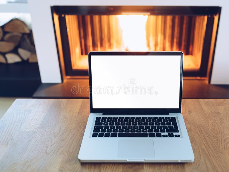 Laptop with Blank Screen on Wooden Table in Front of Burning Fireplace ...