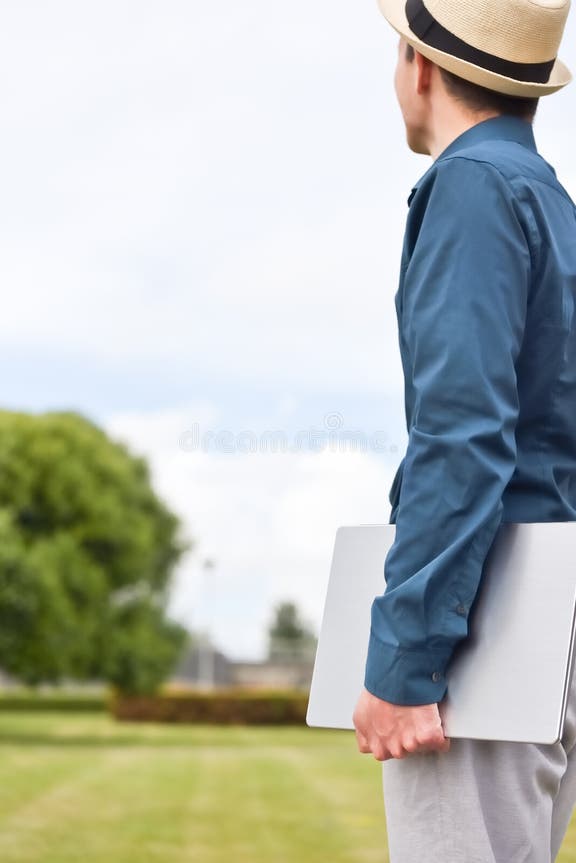 A Laptop Computer in the Hand of a Man Who Thinks and Looks into the ...