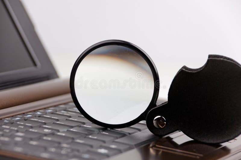Laptop Computer with Keyboard and Magnifying Glass on Top, Representing ...