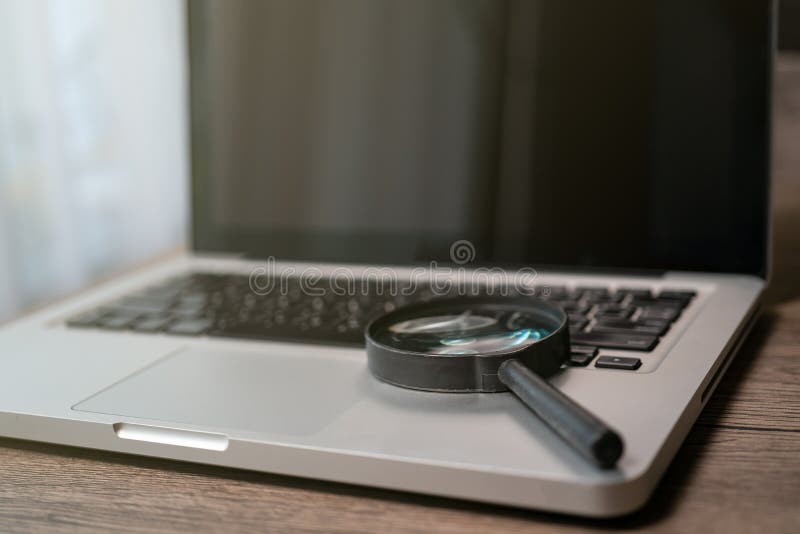 Laptop Computer with Magnifying Glass on the Laptop Keyboard, Concept ...