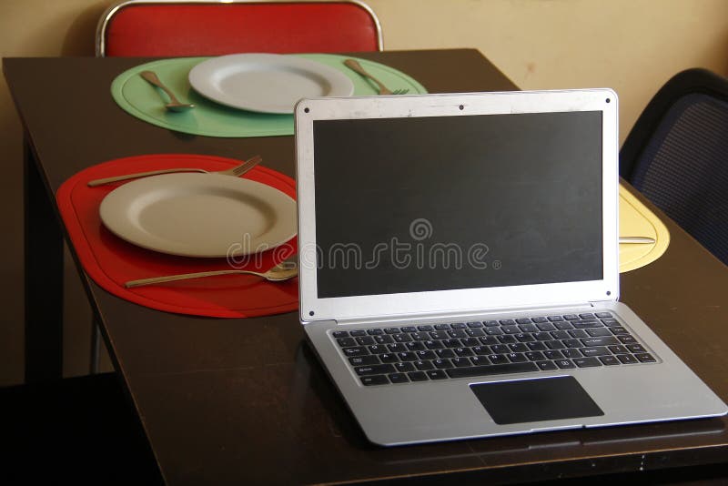 Laptop Computer, Plates and Utensils on a Dining Table Stock Image ...