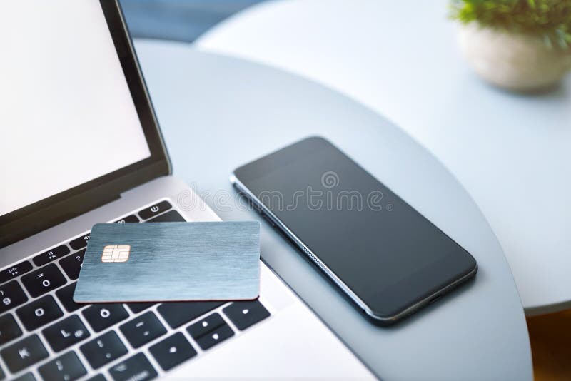 Laptop, Electronic Chip Card and Smartphone on Blue Round Table. Paying ...