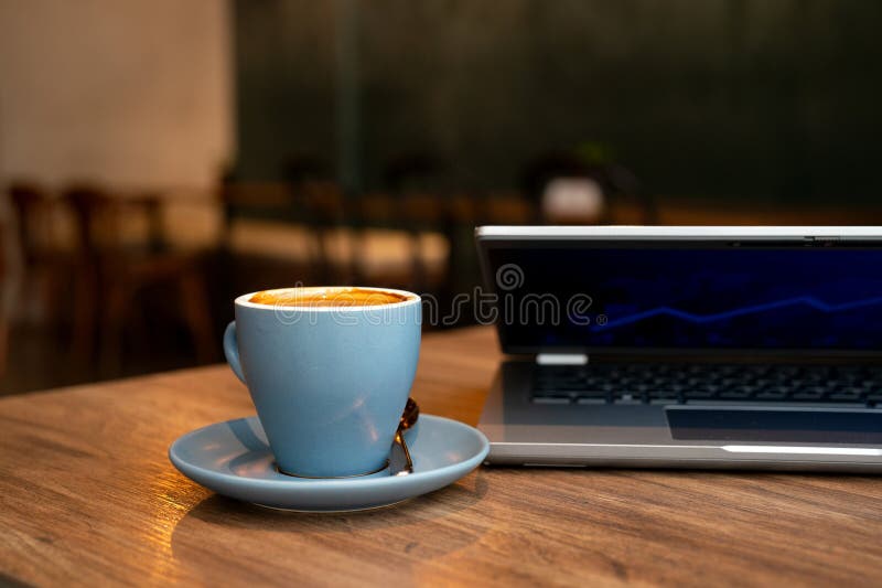 A Laptop with Financial Graph Being Displayed on the Screen and Coffee ...
