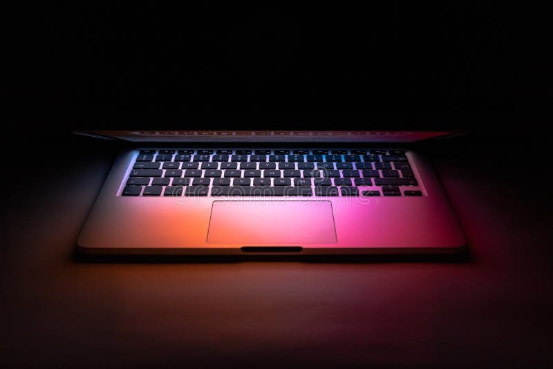 A Laptop Half Closed in the Dark with Colourful Glow Stock Image ...