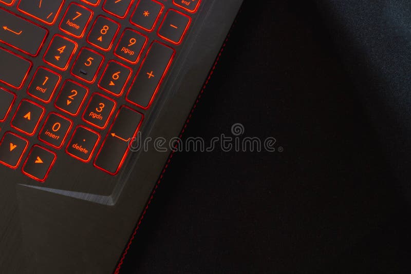 Laptop Keyboard with Red Backlight on a Black Mouse Pad. Background ...