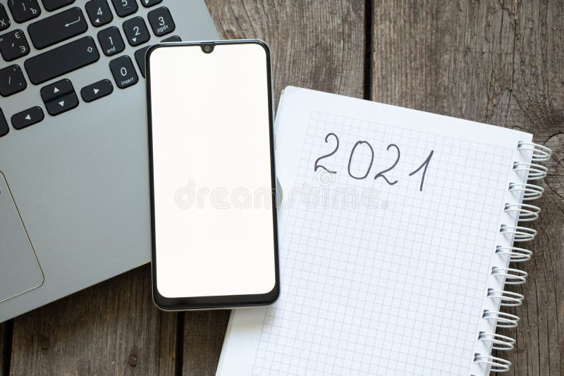 Laptop Phone with White Screen and Notepad with the Text 2021 on a ...