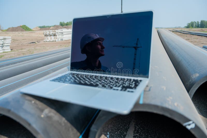 Laptop on Pipes at a Construction Site. Reflection of a Portrait of a ...