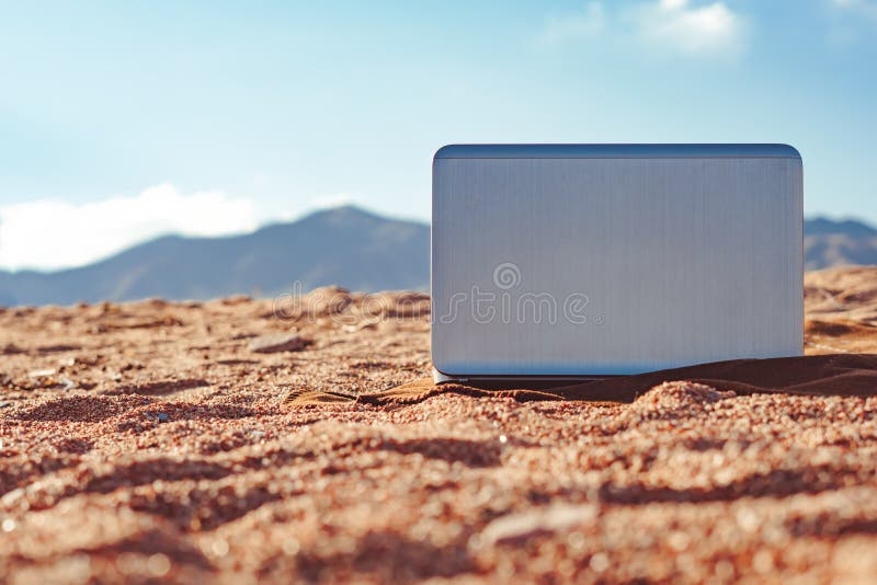 The laptop in the sand stock image. Image of network - 138371281