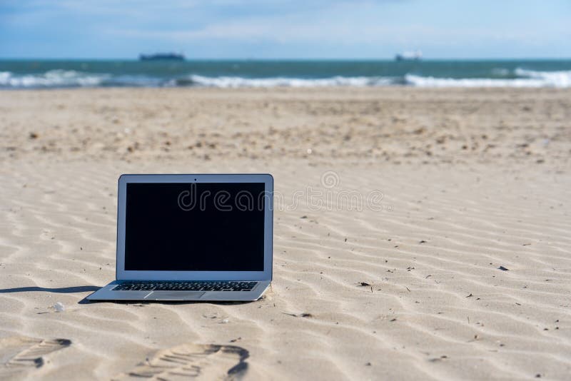 Laptop on a sandy beach stock image. Image of nature - 204975115
