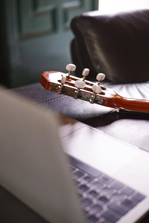 A Laptop on the Sofa To Learn To Play the Guitar Online Stock Image ...