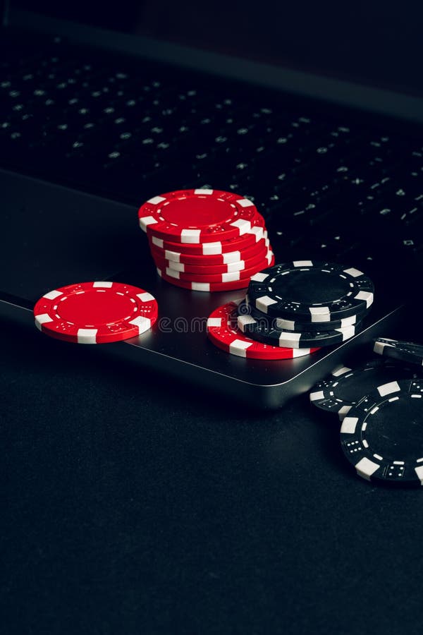 Laptop and Stacks of Poker Chips on a Black Tabletop Stock Photo ...