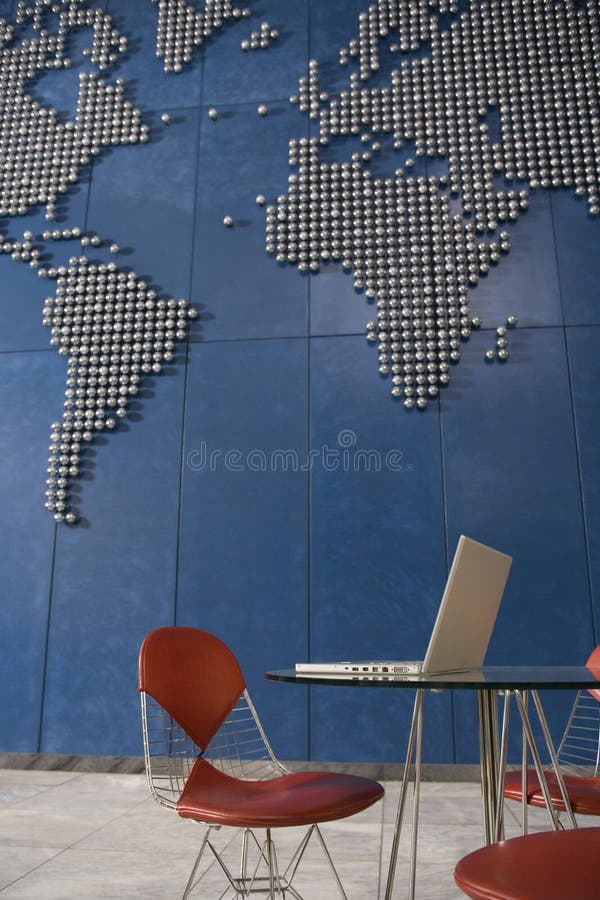 Laptop on Table in Empty Office with World Map on Wall Stock Photo ...