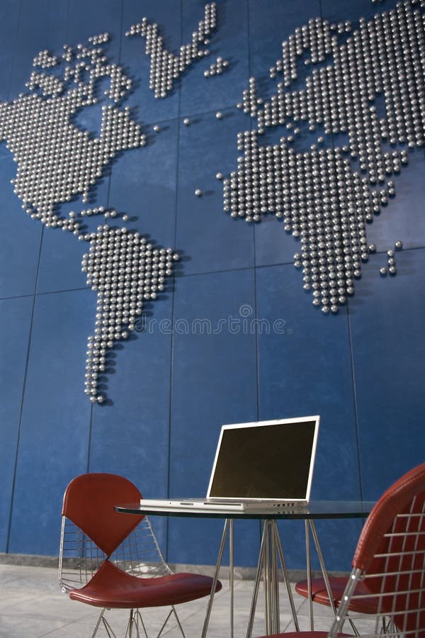 Laptop on Table in Empty Office with World Map on Wall Stock Photo ...