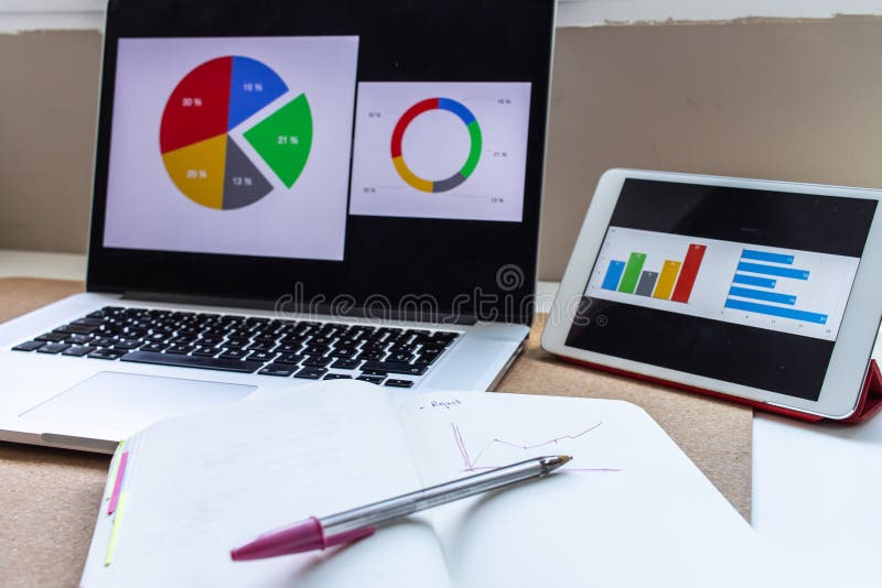 Laptop an Table with Reports and Diagrams. Notebook and Pen on an ...