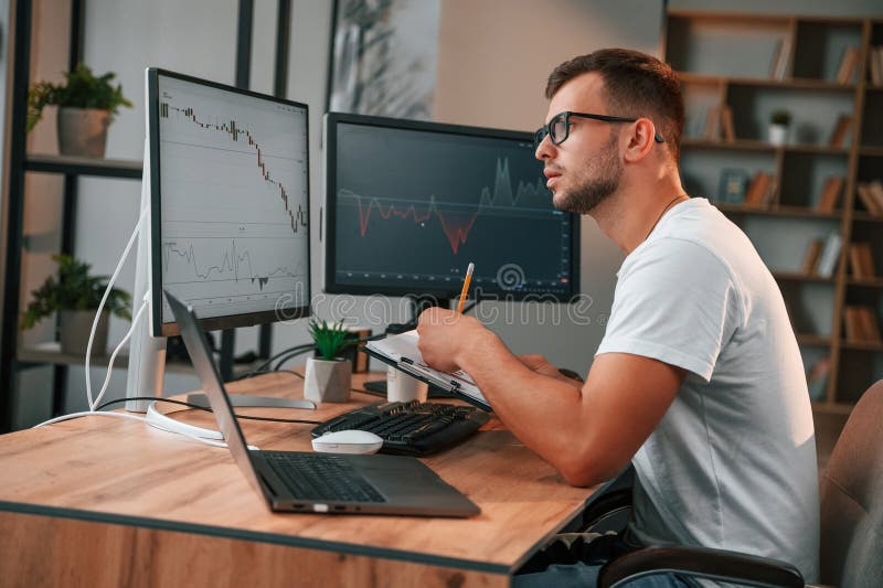 Laptop is on the Table. Young Stock Broker is Working in the Office by ...