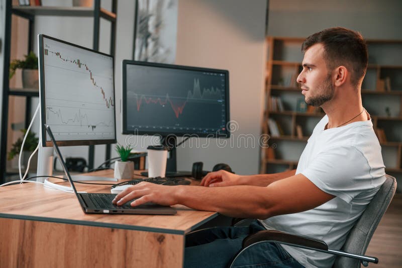 Laptop is on the Table. Young Stock Broker is Working in the Office by ...