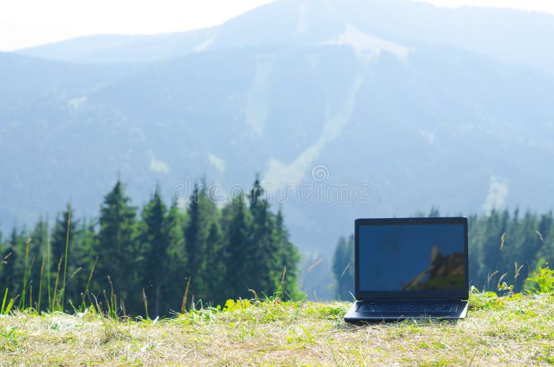 Young Caucasian Man Sitting Outdoor on a Rock Working on a Laptop Pc in ...