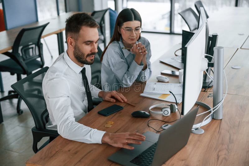 With Laptop. Two Employees are Working in the Office Together Stock ...