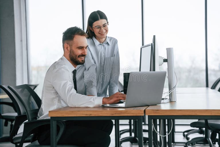 With Laptop. Two Employees are Working in the Office Together Stock ...