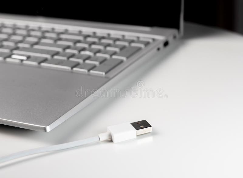 Laptop and White USB Cable on Table Stock Image - Image of perspective ...