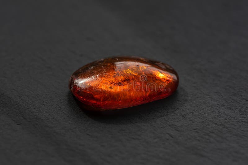 Large Amber Stone Illuminated by Sunlight on a Black Background Close ...