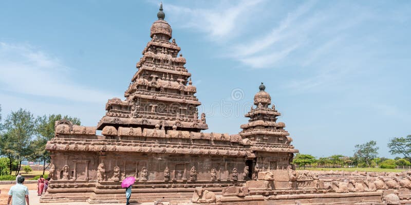 A Large Building with Two Towers and a Group of People Walking Around ...