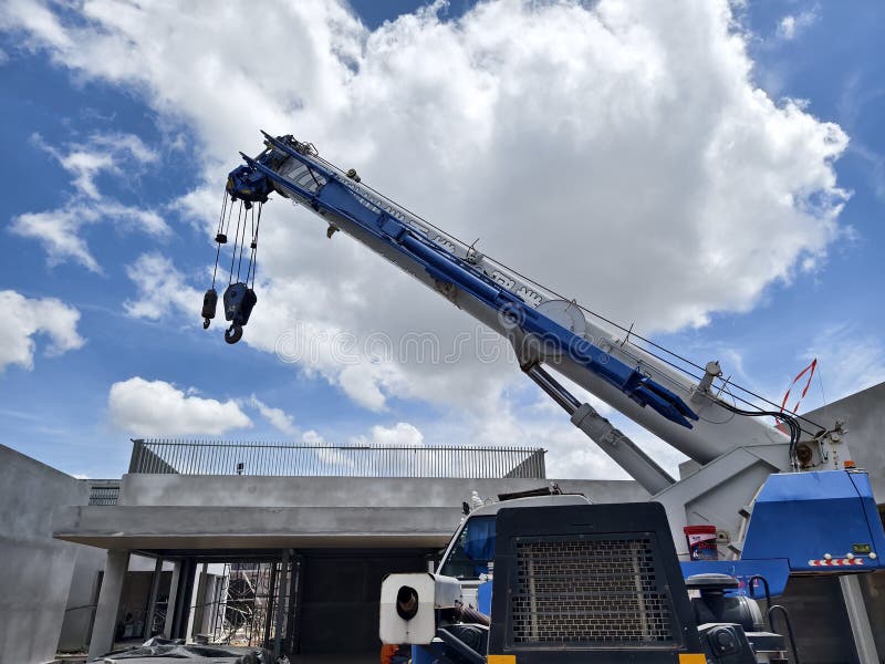 A Large Auto Crane is Parked Right in Front of a Building that is ...