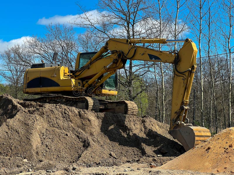 A Large Backhoe Loader Standing on a Pile of Earth Stock Photo - Image ...