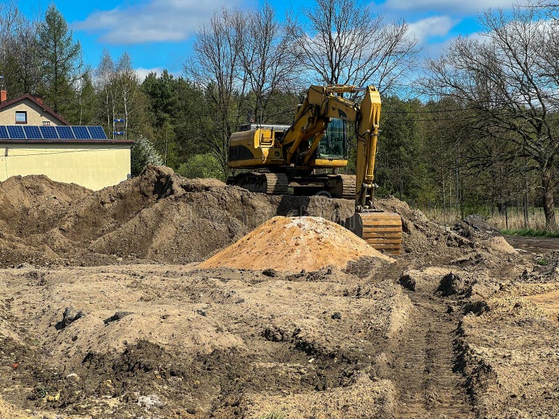A Large Backhoe Loader Standing on a Pile of Earth Stock Photo - Image ...