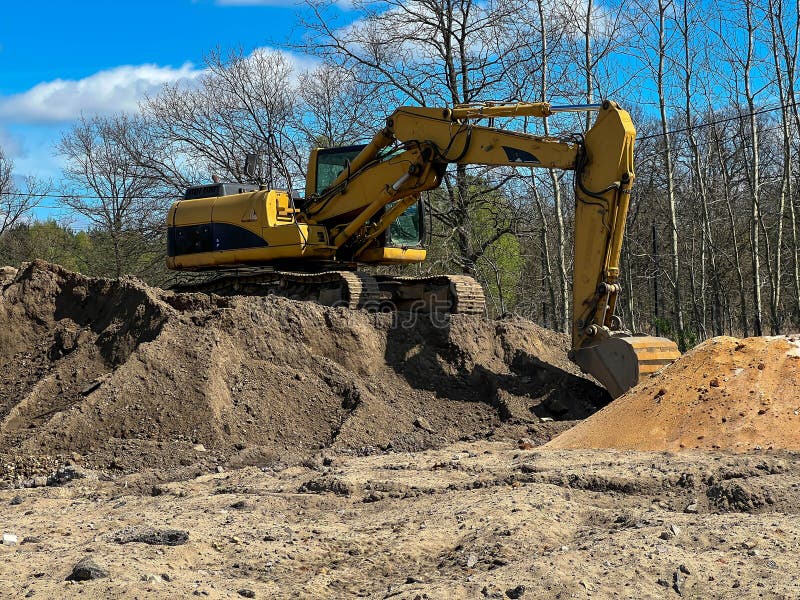 A Large Backhoe Loader Standing on a Pile of Earth Stock Photo - Image ...