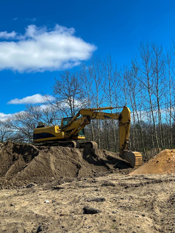 A Large Backhoe Loader Standing on a Pile of Earth Stock Photo - Image ...