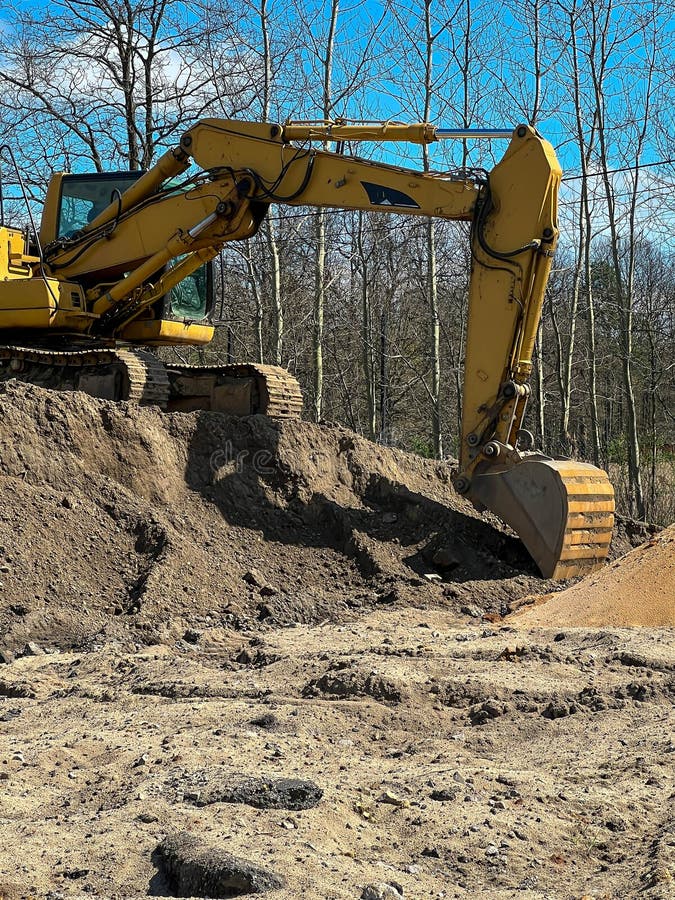 A Large Backhoe Loader Standing on a Pile of Earth Stock Photo - Image ...