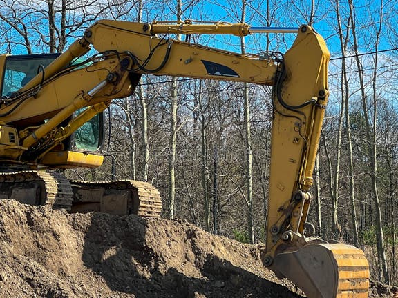 A Large Backhoe Loader Standing on a Pile of Earth Stock Image - Image ...