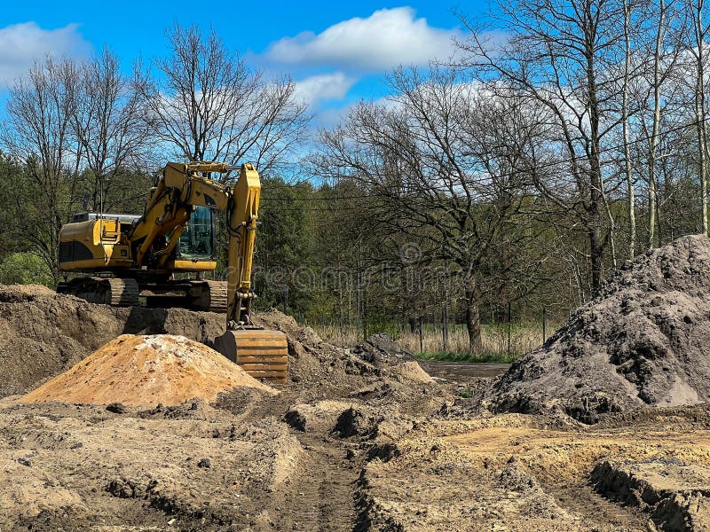 A Large Backhoe Loader Standing on a Pile of Earth Stock Photo - Image ...